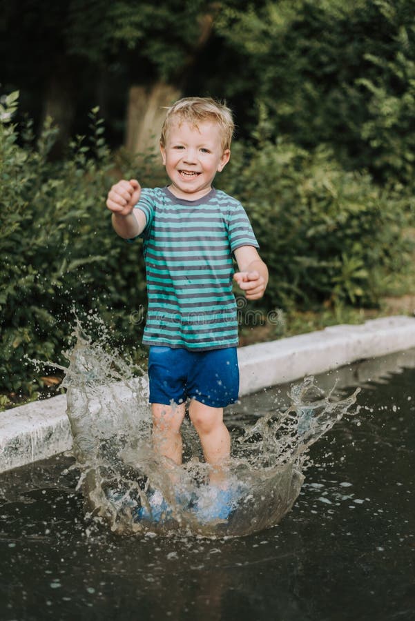 Little Boy Jumping in a Puddle in Summer Stock Photo - Image of feeling ...
