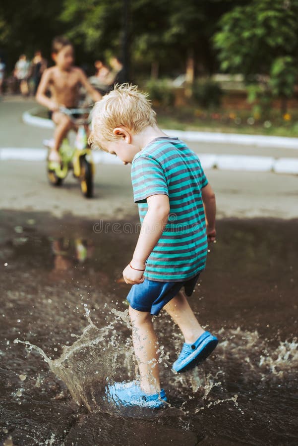 Little Boy Jumping in a Puddle in Summer Stock Image - Image of jersey ...