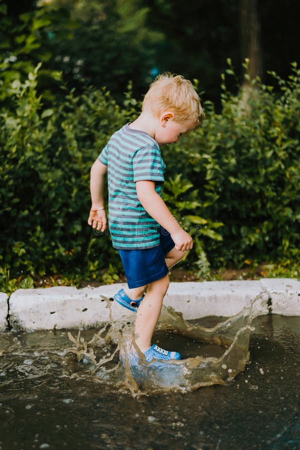 Little Boy Jumping in a Puddle in Summer Stock Image - Image of game ...