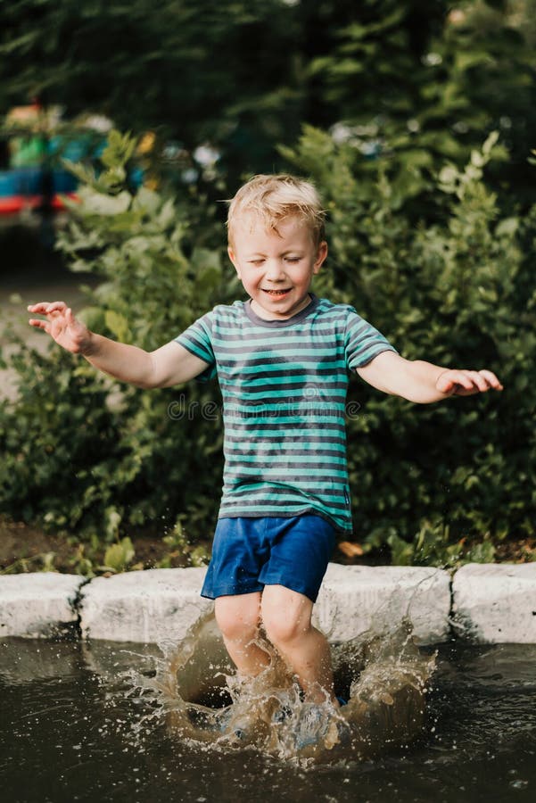 Little Boy Jumping in a Puddle in Summer Stock Image - Image of baby ...