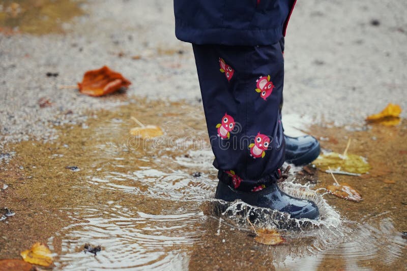 Child Jumping into Rain Puddle in Autumn Stock Image - Image of shoes ...