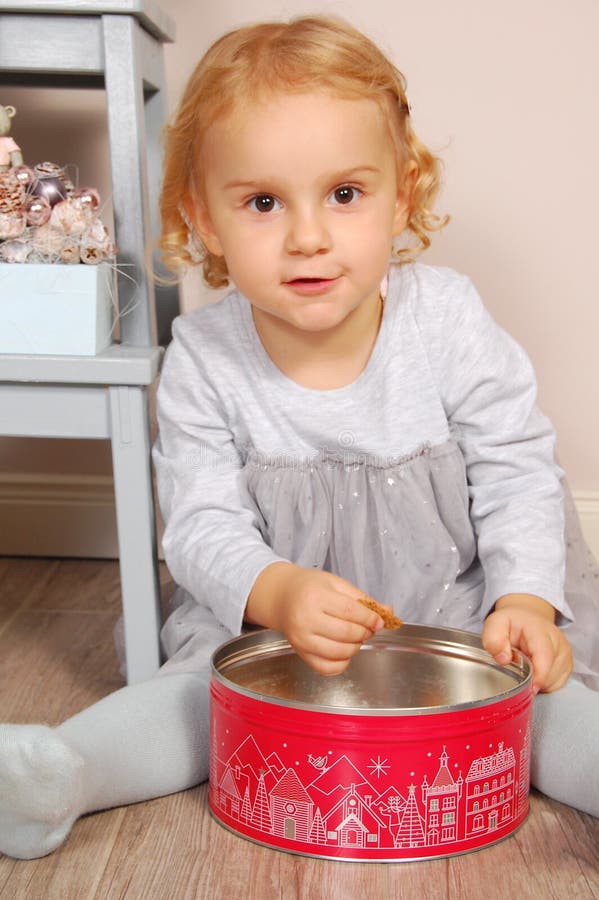 Child in the Kitchen Sitting and Eating Cookies in the Shape of a ...