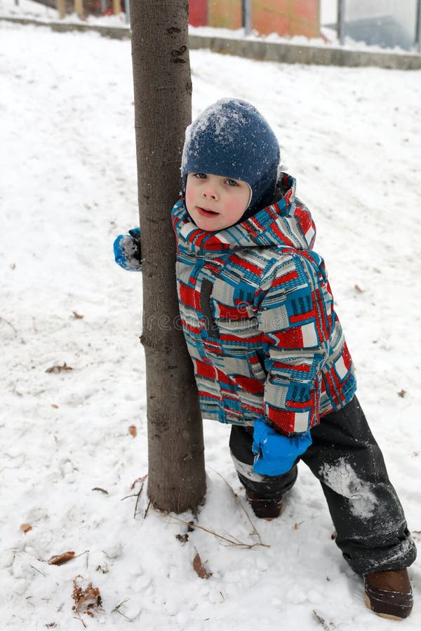 Child leans on tree trunk stock photo. Image of childhood - 134817530
