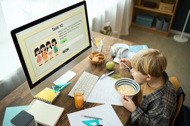 Child Learning Online while Eating Breakfast Stock Photo - Image of ...