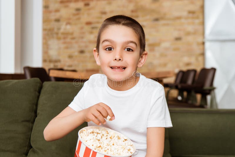 Child Looking at Camera while Eating Stock Photo - Image of cinema ...