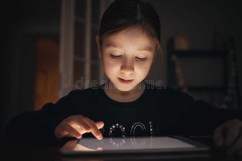 Child Looks at Digital Tablet in Dark and Touches Screen Stock Photo ...