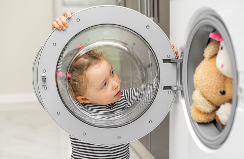 The Child Looks through the Door of the Washing Machine. Stock Image ...