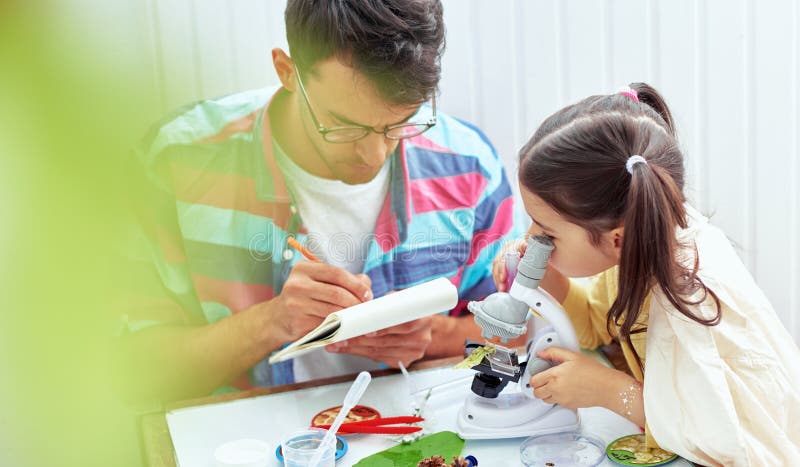 Child Looks through Microscope while Doing Science Experiments in the ...