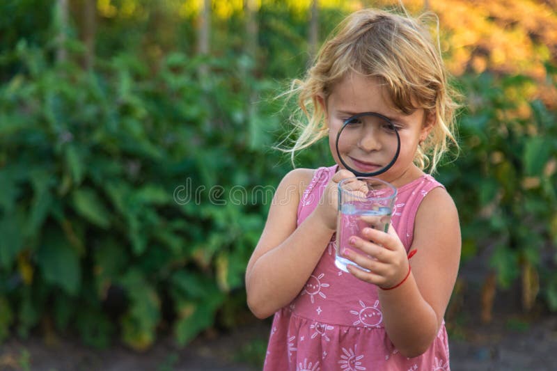 A Child Looks at Water through a Magnifying Glass. Selective Focus ...