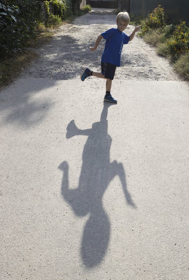 Child Makes a Funny Shadow on the Asphalt during a Summer Walk Stock ...