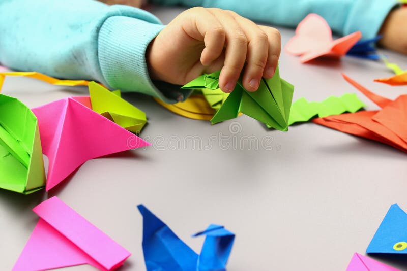 Child Makes Origami Crafts from Colored Paper, Hands Close-up Stock ...