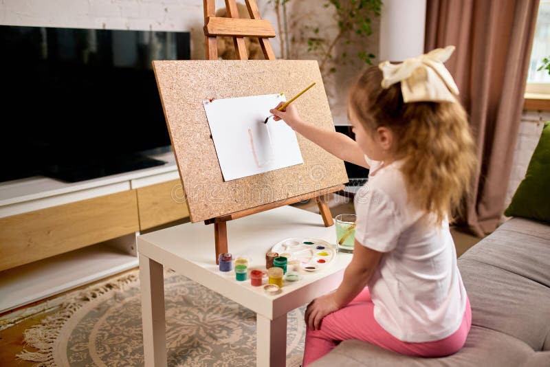 Child Painting on Easel while Following Virtual Tutorial, Using Digital ...