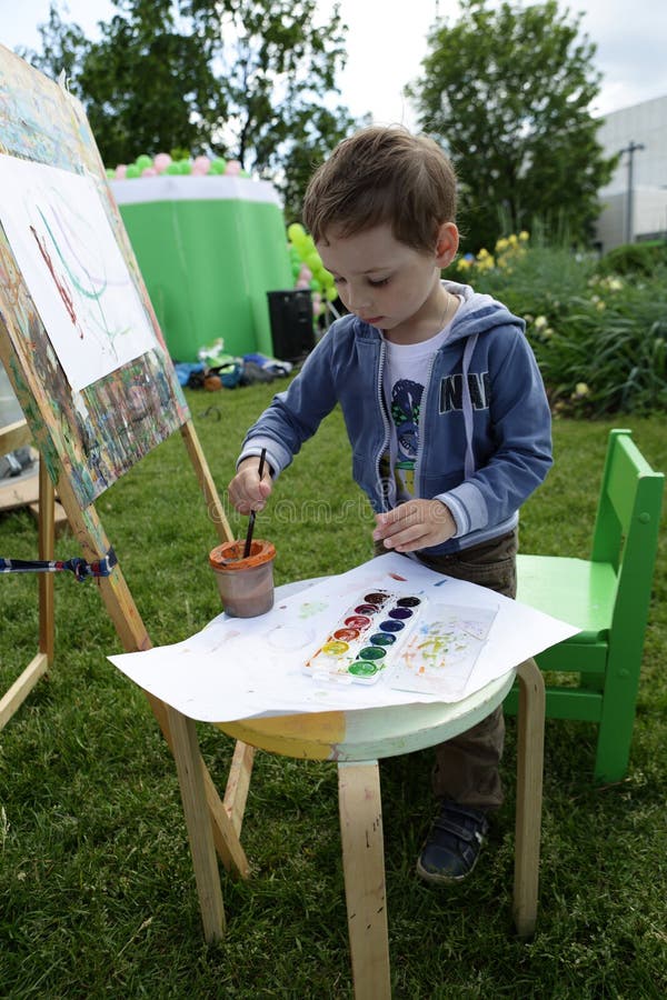 Child painting at easel stock photo. Image of cute, activity - 55297952