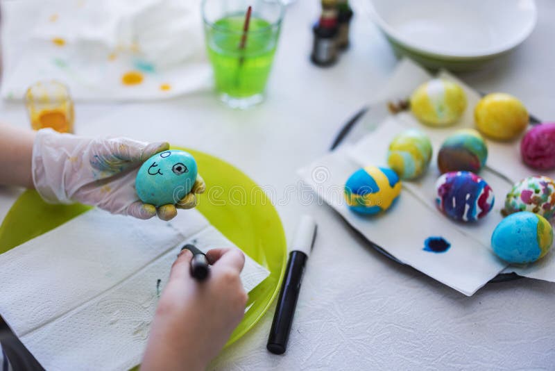 Child Painting Easter Egg with Smiley Face, with Finished Decorated ...