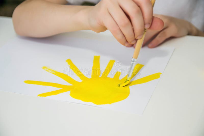 A Child Paints a Yellow Sun at a White Table Stock Photo - Image of ...