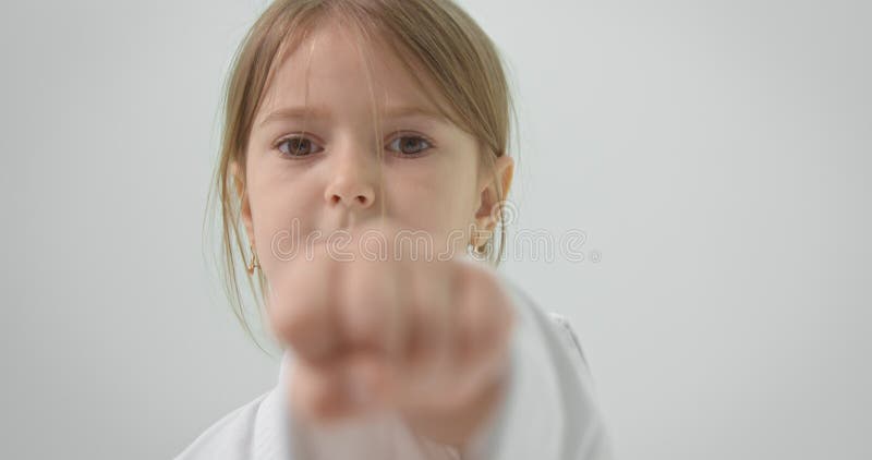 A Little Girl Dressed in a Kimono Kicks and Looks at the Camera. Kick ...