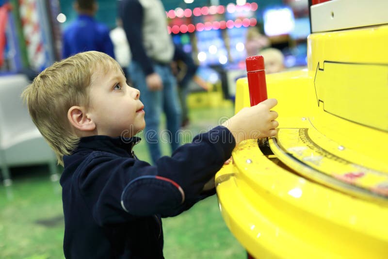 Child playing arcade game stock image. Image of game - 128369525