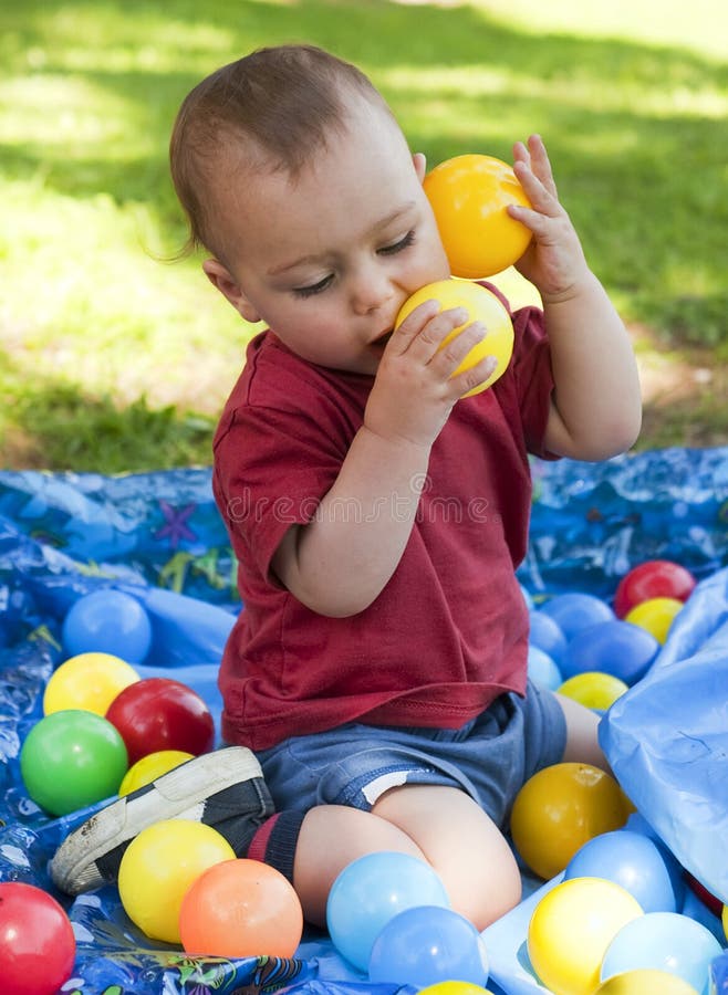 Child Playing with Balls in Garden Stock Photo - Image of expressions ...