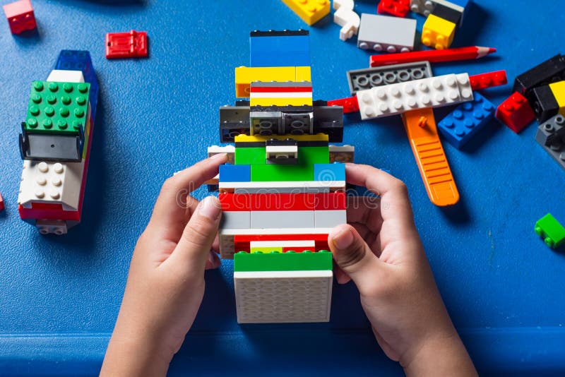 Child Playing and Building with Colorful Plastic Bricks on a Blue Table ...