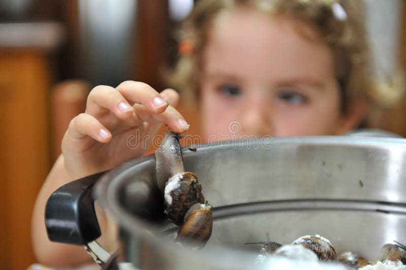Child playing with a snail stock photo. Image of shell - 180615006
