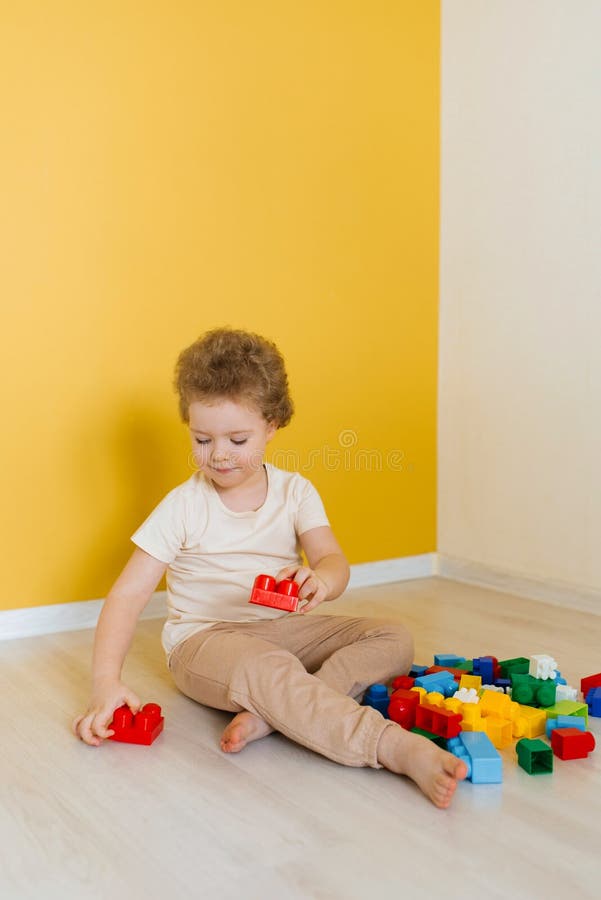 Child is Playing with Colorful Cubes at the Table. Kid Has Fun and ...