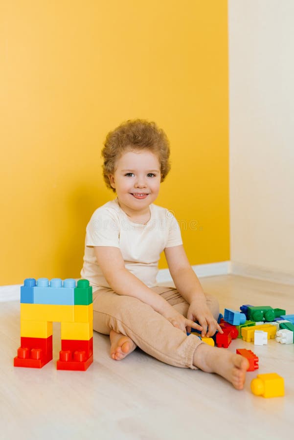 Child is Playing with Colorful Cubes at the Table. Kid Has Fun and ...