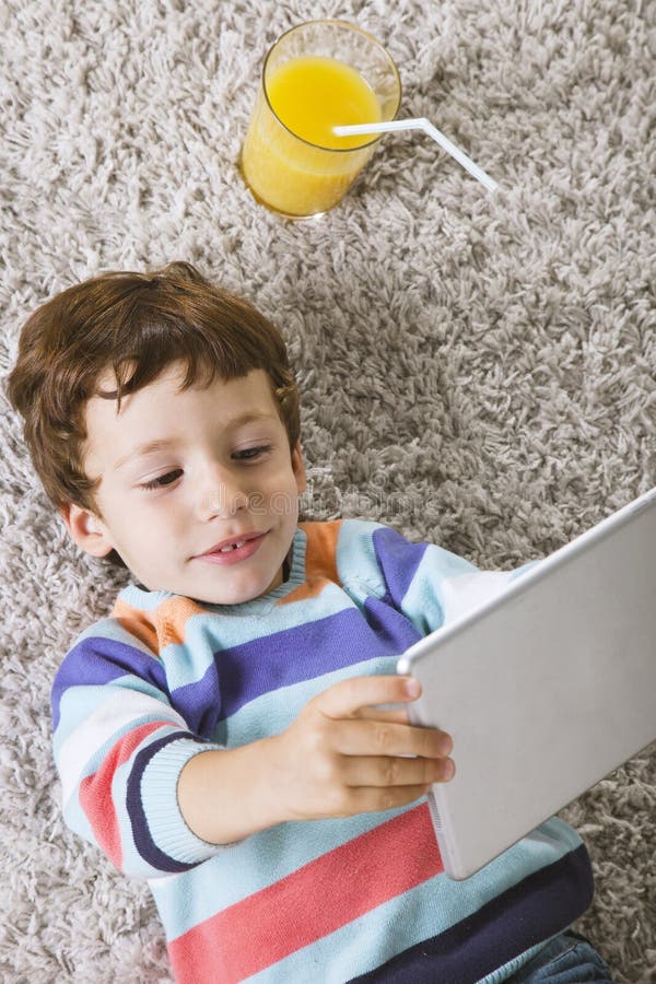 Child Playing with Digital Tablet Stretched on a Carpet Stock Image ...