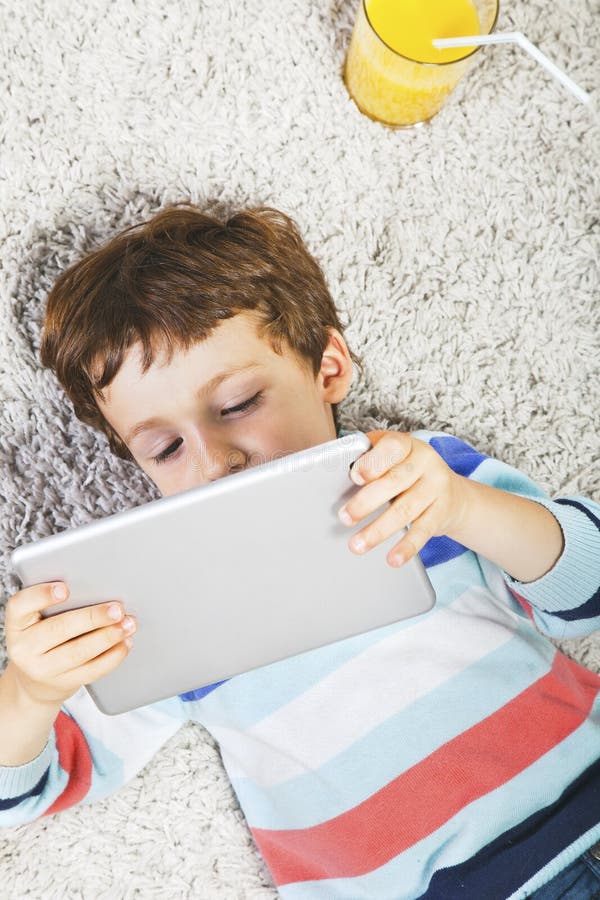 Child Playing with Digital Tablet Stretched on a Carpet Stock Photo ...