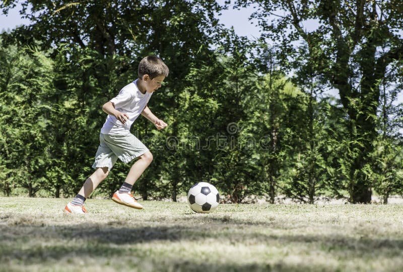 Child Playing Football in a Stadium Stock Photo - Image of children ...