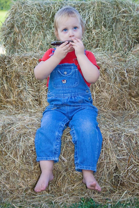 Child playing harmonica. stock image. Image of overalls - 10609613