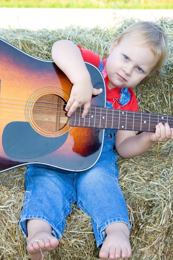 Child playing instrument. stock image. Image of strum - 10594791