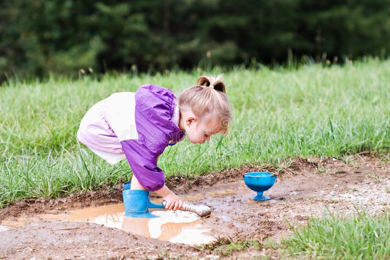 Child Playing in Mud Puddle Stock Photo - Image of jacket, boots: 11118354