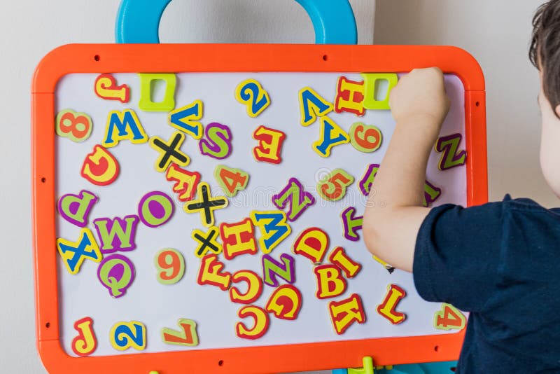 Child Playing with Numbers and Letters on a Magnetic Board. School ...