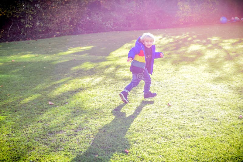Child Playing Outside in a Garden during Day Time with Bubbles he is ...