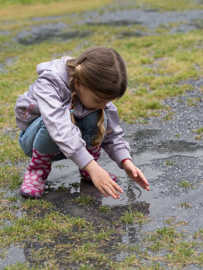 The Child Playing in a Puddle Stock Photo - Image of puddle, braiding ...