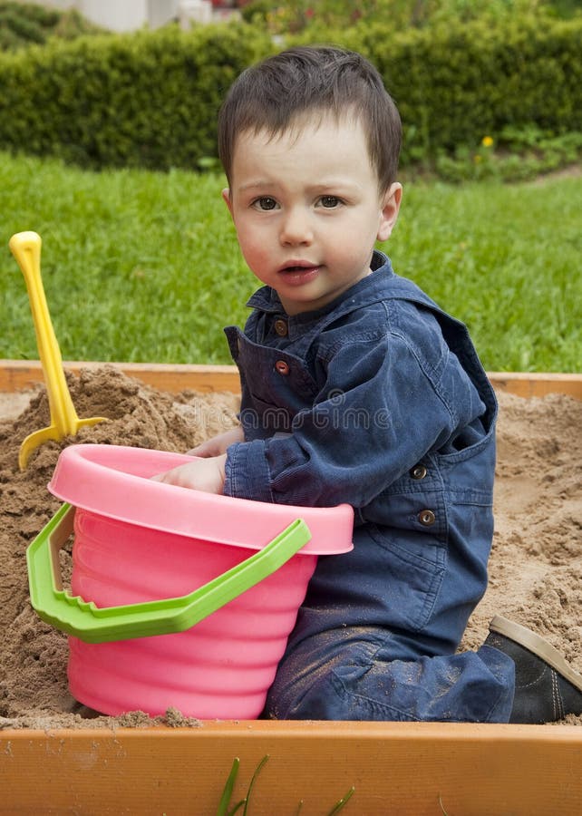 Child playing in sandbox stock photo. Image of childhood - 14060370