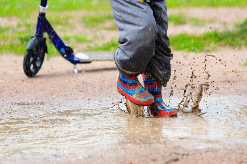 Child jumping in puddle stock image. Image of park, jacket - 33198493