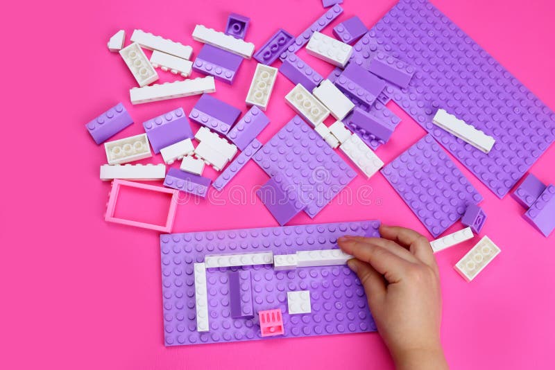 Child Plays with Colored Toy Blocks on a Pink Table Stock Image - Image ...