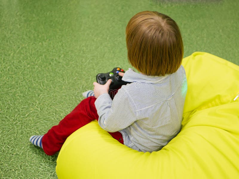 A Child Plays a Game Console Alone. Plays Video Games Stock Photo ...