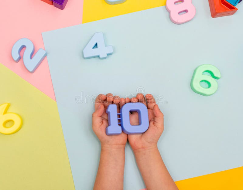 The Child Plays with Multi-colored Numbers. Child`s Hands Hold Numbers ...