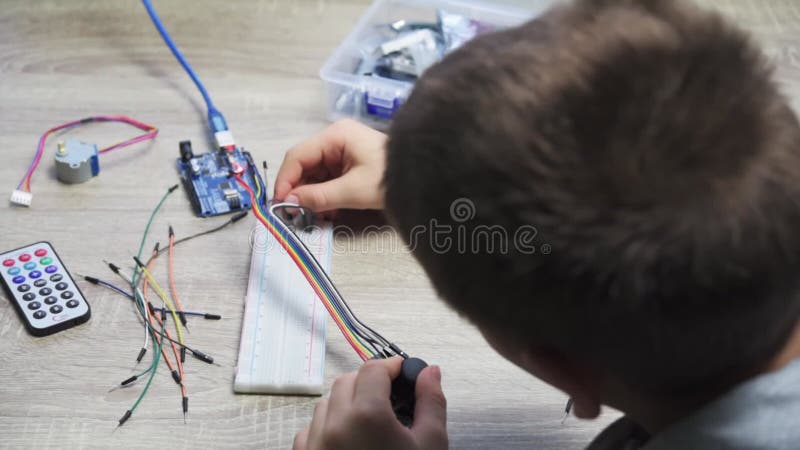 A Child Plugging Cables To Sensor Chips while Learning Arduino Coding and Robotics Stock Footage ...