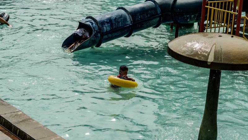 A Child is in a Pool with a Yellow Float Stock Photo - Image of ...