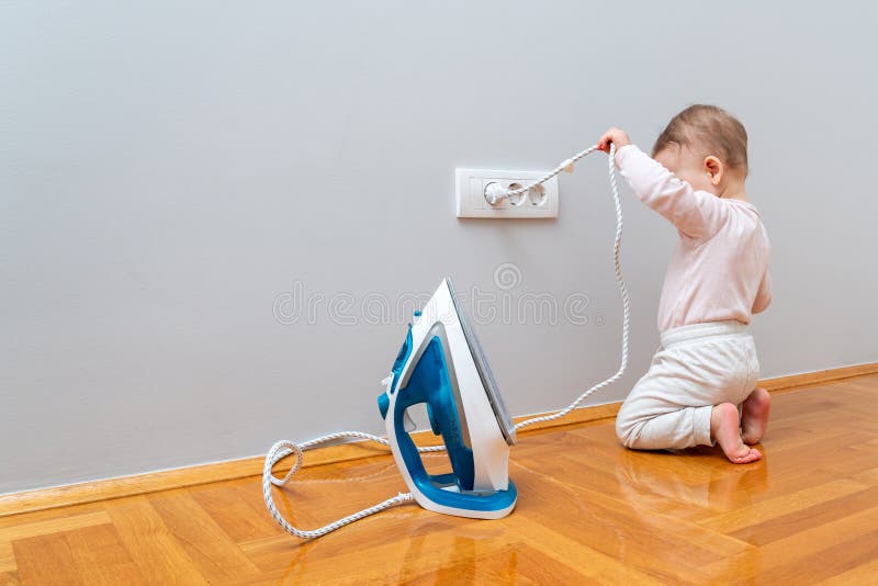 The Child Pulls the Electrical Plug Out of the Socket To Let the Iron ...