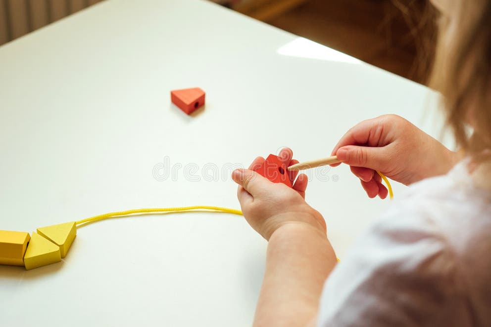 Child Putting Beads on a String. Bead Stringing Activity Stock Image ...