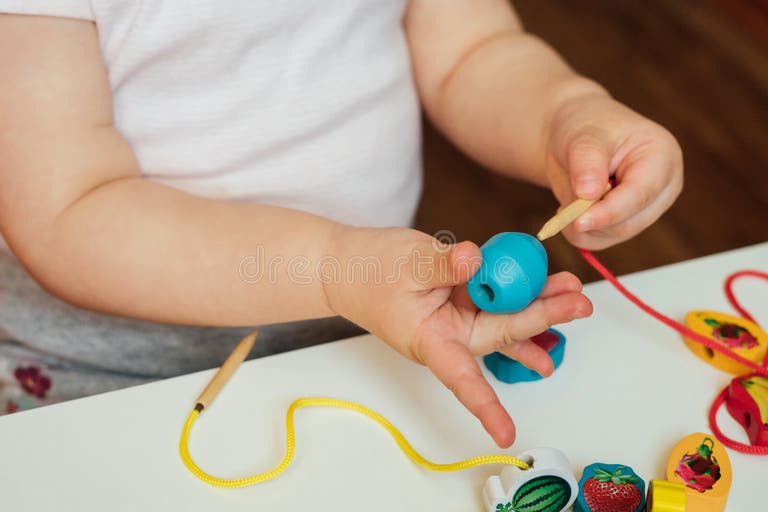 Child Putting Beads on a String. Bead Stringing Activity Stock Photo ...