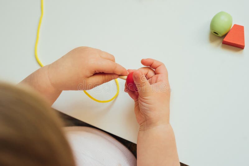 Child Putting Beads on a String. Bead Stringing Activity Stock Image ...