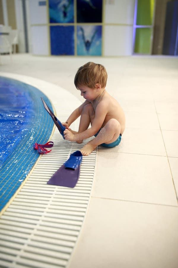 Child putting on flippers stock photo. Image of pool - 103295852