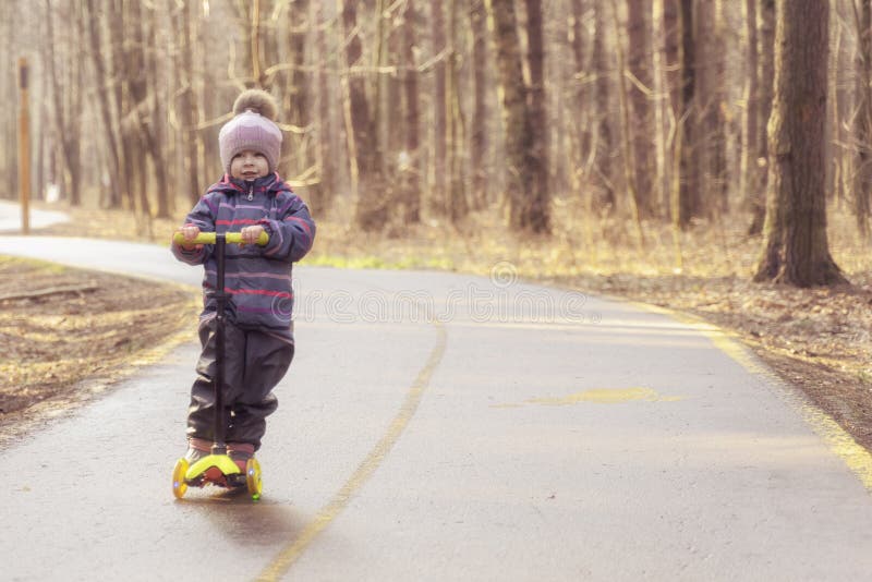 A Child Races on a Scooter Along an Asphalt Road Stock Photo - Image of ...