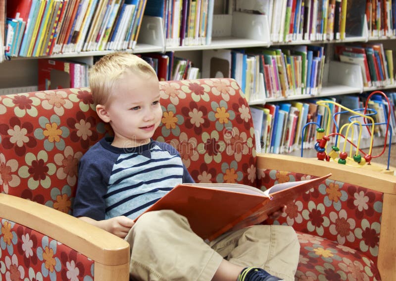 Child Reading a Book on a Couch at the Library Stock Photo - Image of ...