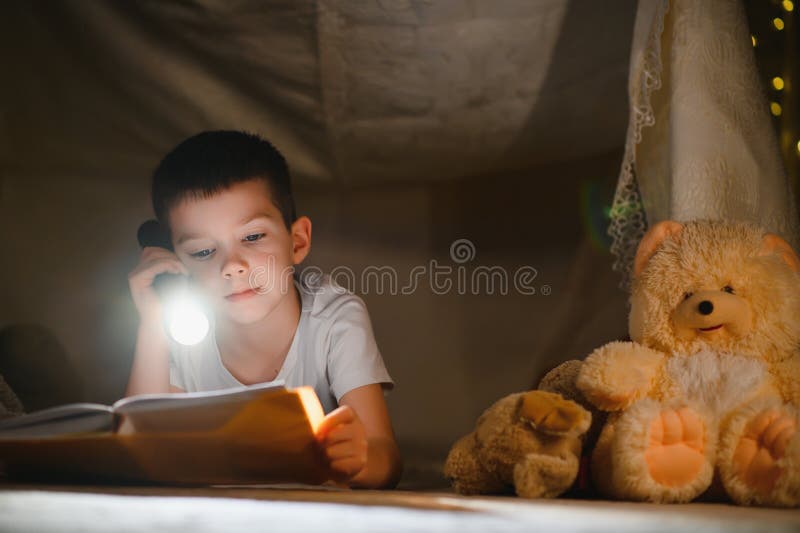 The Child is Reading a Book with a Flashlight Stock Image - Image of ...